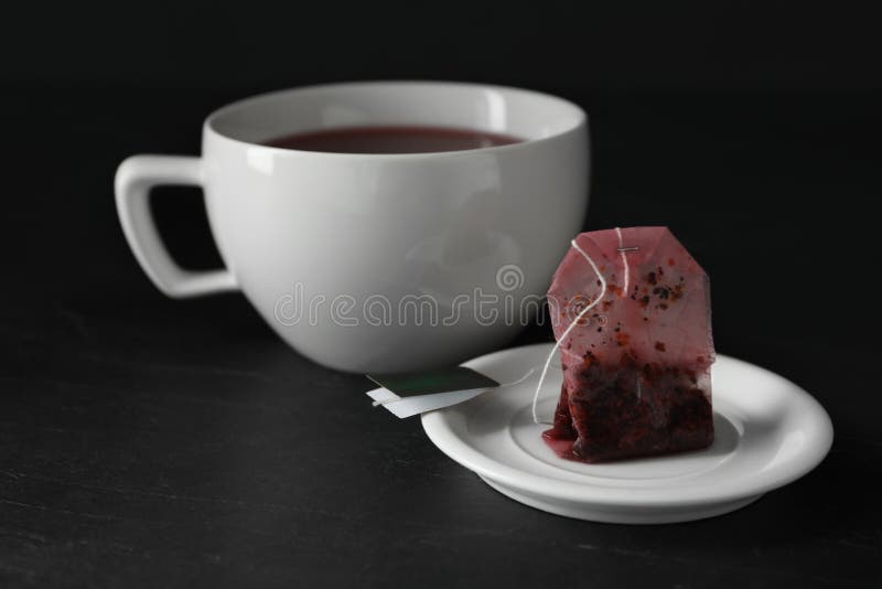 Used Tea Bag and Cup of Drink on Black Table Stock Image - Image of ...