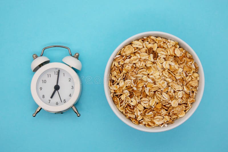 Useful Breakfast of Cereal and Alarm Clock on Blue Table Close-up Stock ...