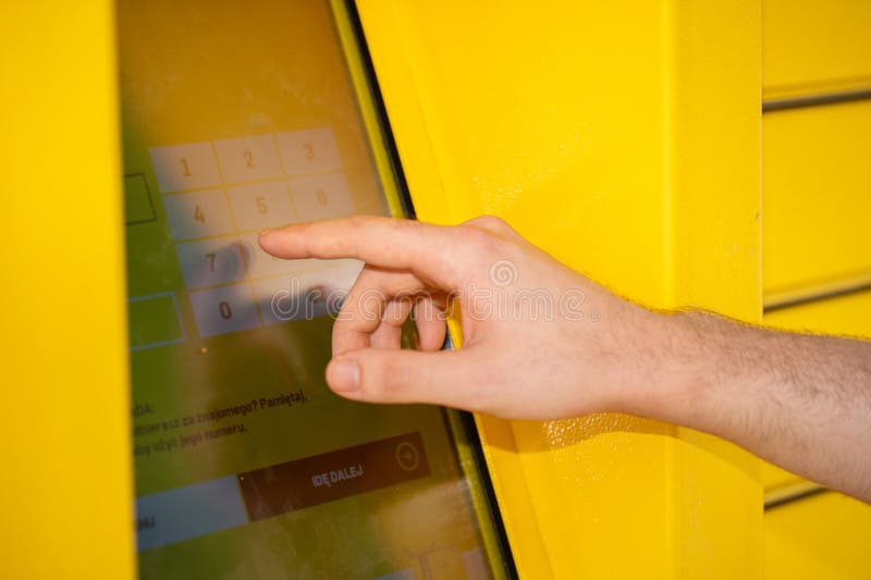 User Engaging with a Touchscreen Kiosk Located in a Bright Yellow ...