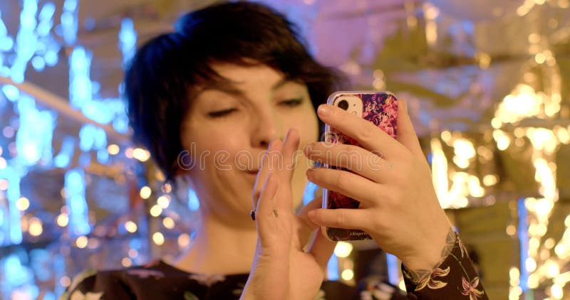 She Uses the Phone in Her Hands Against the Backdrop of Light ...