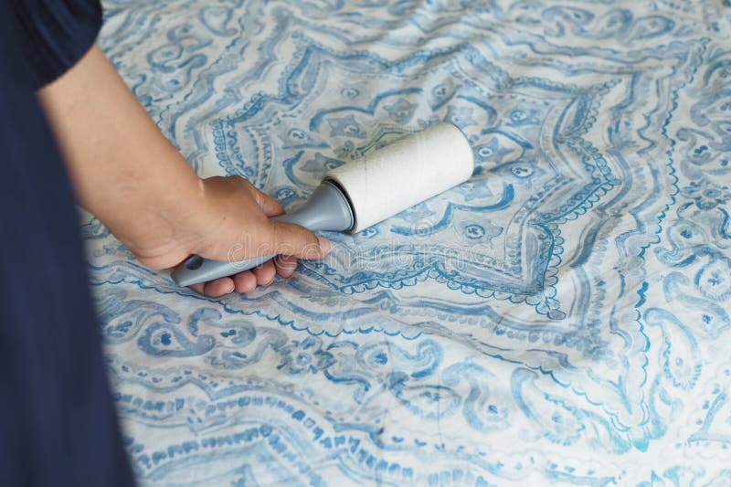Using an Adhesive Roller To Remove Lint and Fluff from a Bed . Stock ...