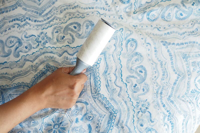 Using an Adhesive Roller To Remove Lint and Fluff from a Bed . Stock ...