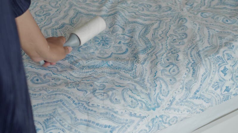 Using an Adhesive Roller To Remove Lint and Fluff from a Bed . Stock ...