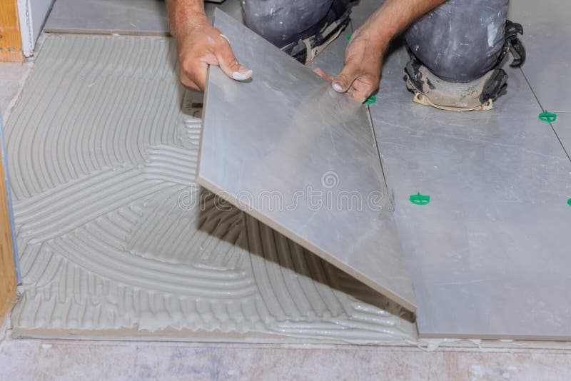 Using Adhesive To Install Ceramic Floor Tiles in a Home Construction ...