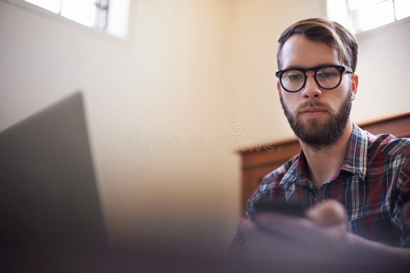 Using All the Latest Tech. a Handsome Young Hipster Working on a Laptop ...