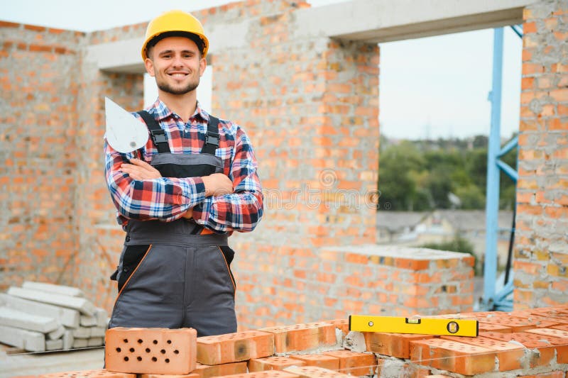 Using Bricks. Young Construction Worker in Uniform is Busy at the ...