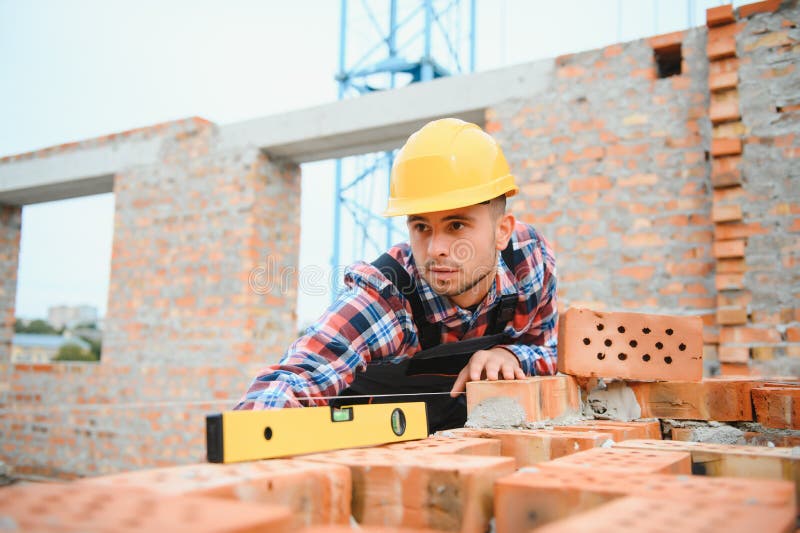 Using Bricks. Young Construction Worker in Uniform is Busy at the ...