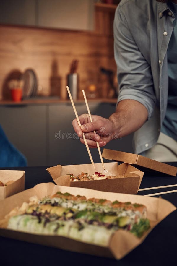 Using Chopsticks. Man in Casual Clothes is with Sushi that is in the ...