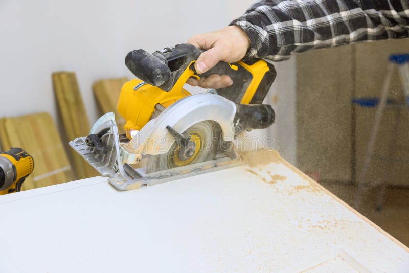 Using Circular Hand Saw, Carpenter Cuts a Wooden Board Stock Photo ...