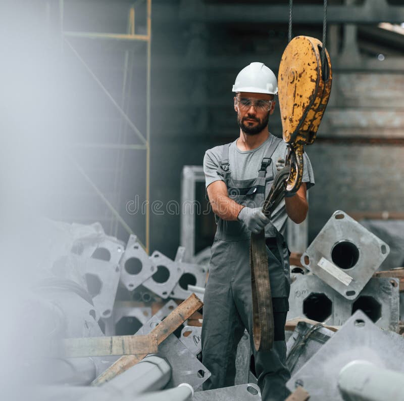 Using Crane Hook. Young Factory Worker in Grey Uniform Stock Image ...