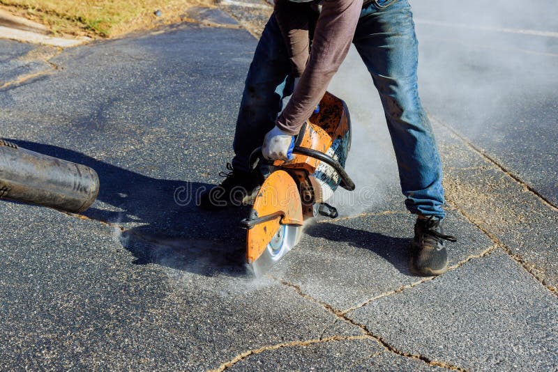 Using Diamond Blade Saw Machine, a Construction Worker Cuts Asphalt ...
