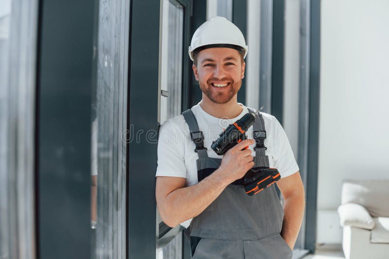 Using Drill by Installing Windows. Repairman is Working Indoors in the ...