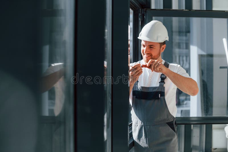Using Drill by Installing Windows. Repairman is Working Indoors in the ...