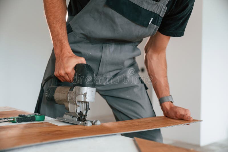 Using the Electric Machine Tool To Cut the Plank. Man is Installing New ...