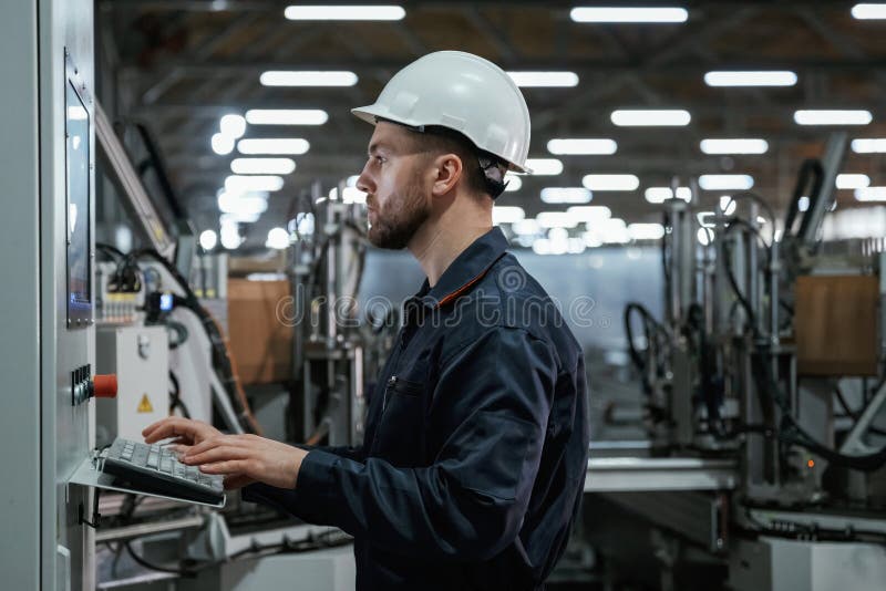 Using Equipment, Operator. Factory Worker is Indoors with Hard Hat ...