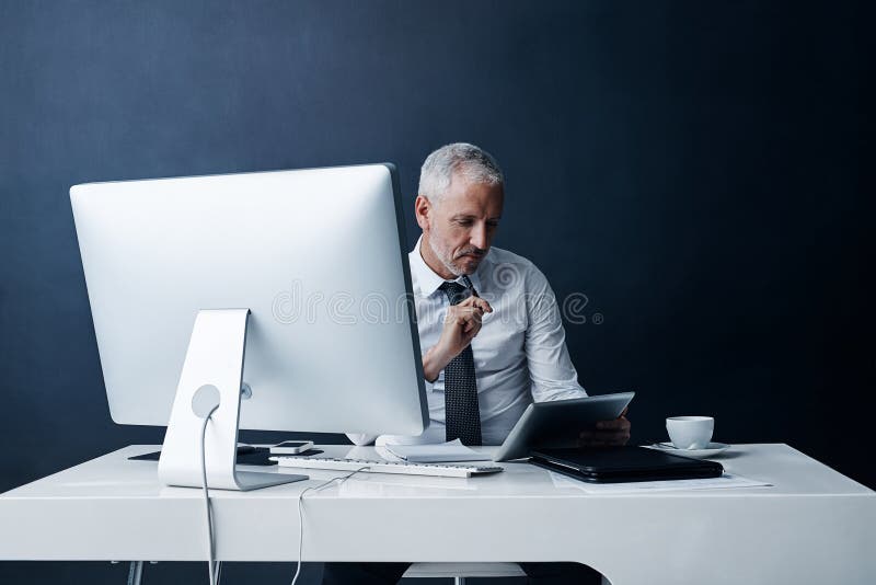 Using His Brain. a Mature Businessman Working on His Tablet. Stock ...