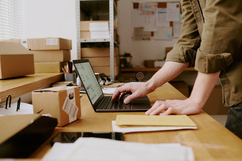 Using Laptop in Modern Office Surrounded by Boxes and Paperwork Stock ...