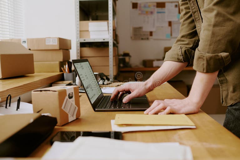 Using Laptop in Modern Office Surrounded by Boxes and Paperwork Stock ...