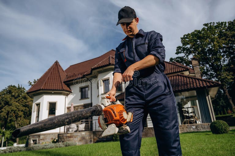 Using Leaf Blower. Professional Gardener is on the Lawn Stock Photo ...