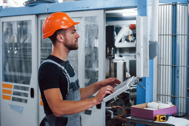 Using Machine To Program Operations. Industrial Worker Indoors in ...