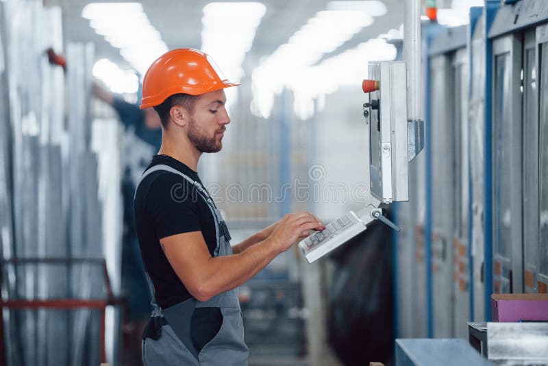 Using Machine To Program Operations. Industrial Worker Indoors in ...