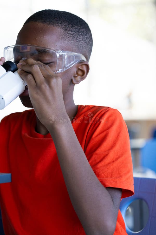 Using Microscope, Boy in School Wearing Safety Goggles, Focusing on ...