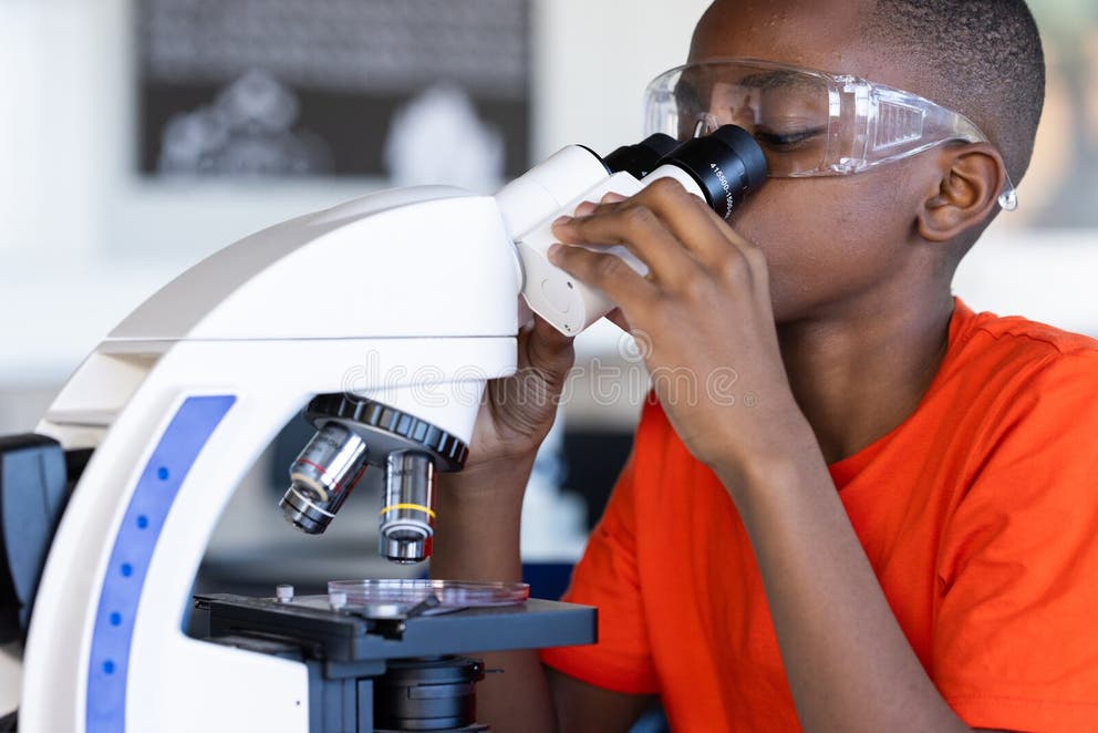 Using Microscope, Student in School Wearing Safety Goggles, Focusing on ...
