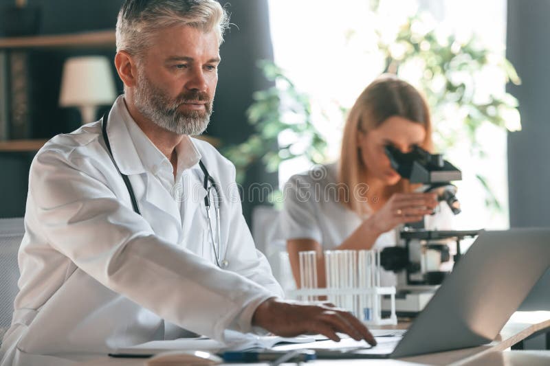 Using Microscope. Two Clinic Workers are Indoors Together Stock Photo ...