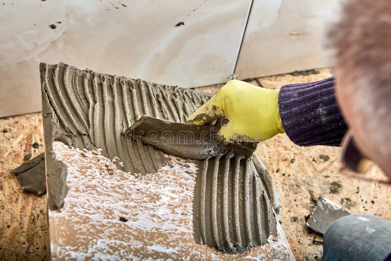 Using Notched Trowel To Apply Cement Mortar Tile Adhesive To Tiles ...