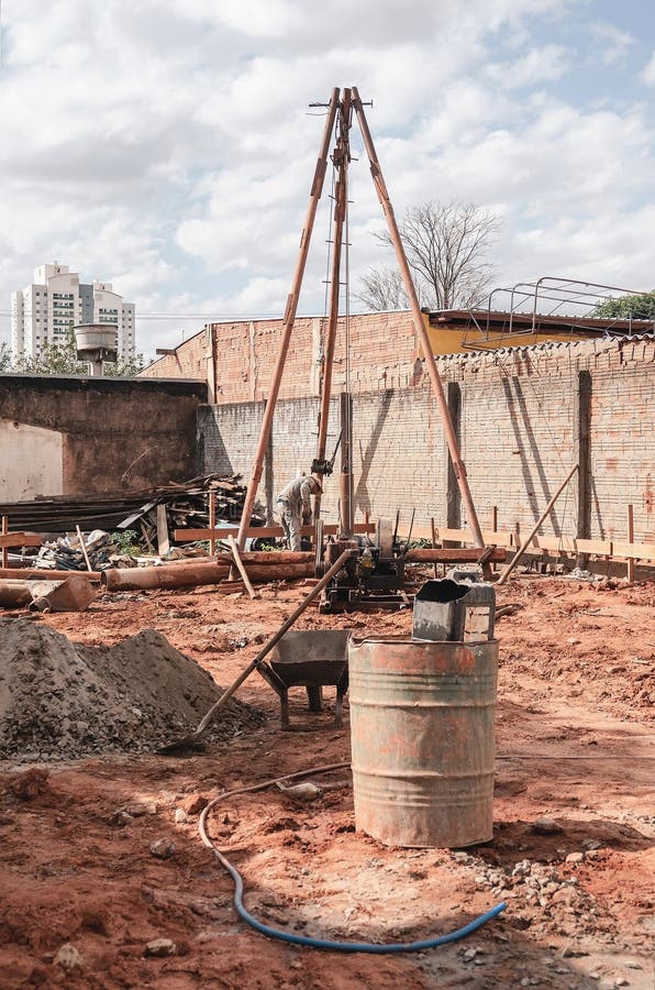 Using a Pile Driver on a Tripod To Dig the Soil and Make the Foundation ...