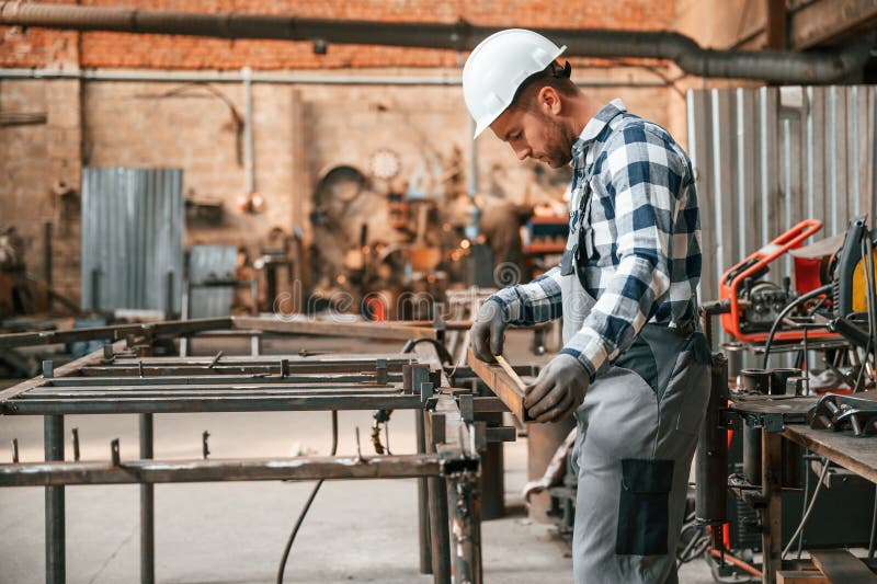 Using Professional Tools. Factory Male Worker in Uniform is Indoors ...