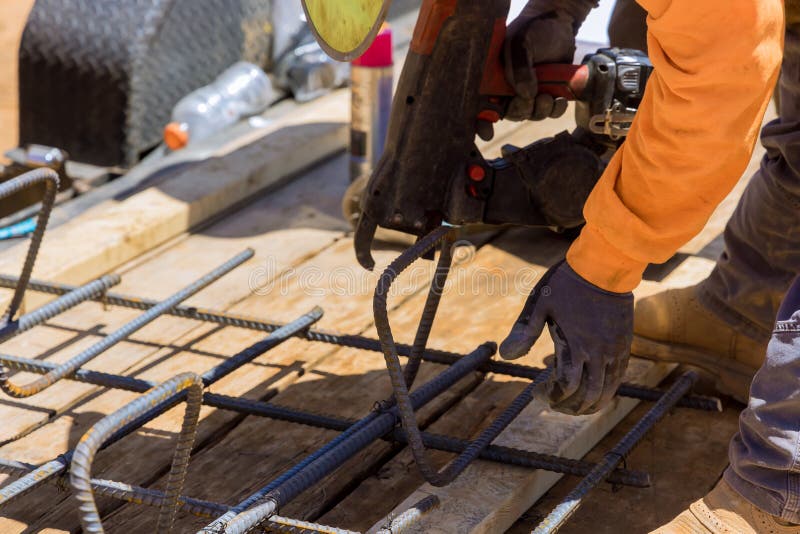 Using a Rebar Tying Tool, Construction Worker Twists Steel Bars with ...