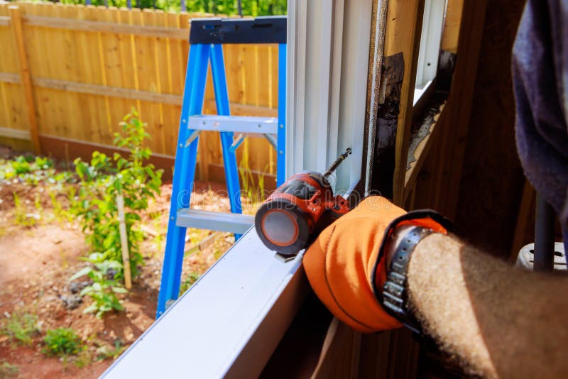 Using Screwdriver, Construction Worker Installs Plastic Windows in a ...