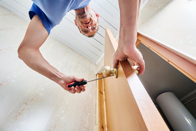 Securing Door Knobs by Tightening Screws with Screwdriver To Fix ...