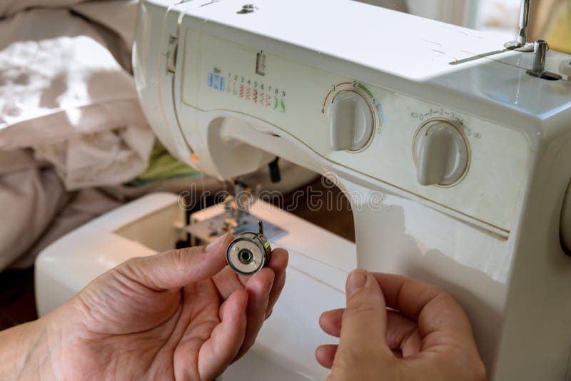 Using a Sewing Machine, the Seamstress Puts the Threads from the Metal ...