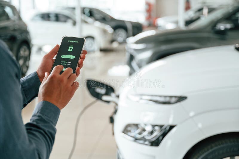 Using Smartphone App for Monitoring Charging Process. Close Up View of ...