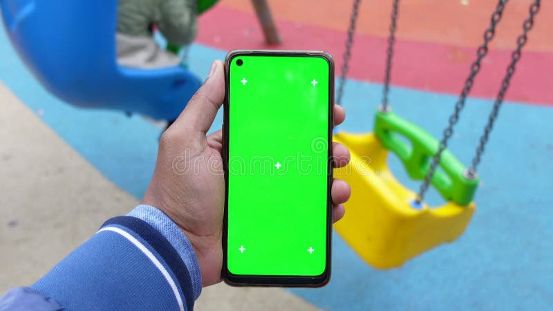 Using a Smartphone with a Green Screen in a Vibrant Playground Setting ...