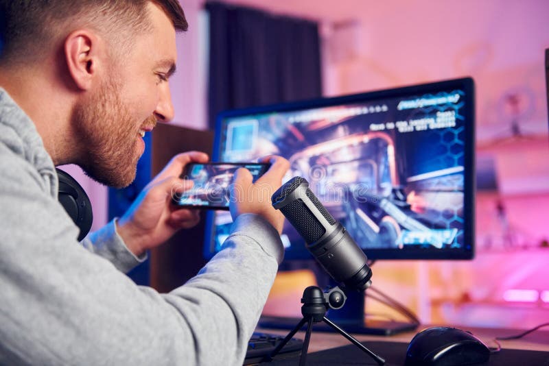 Using the Smartphone. Online Streamer Playing FPS Shooter Game at Home ...