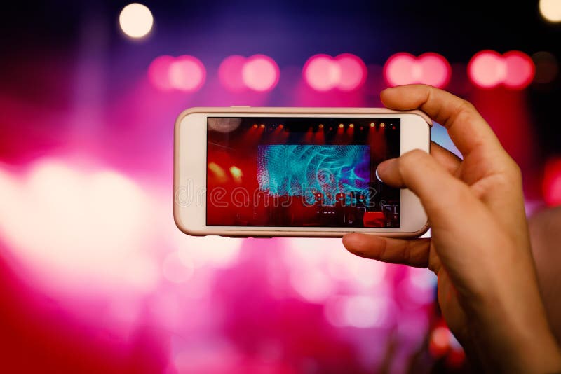 Using a Smartphone in a Public Event. Holding a Mobile Phone in Hands ...