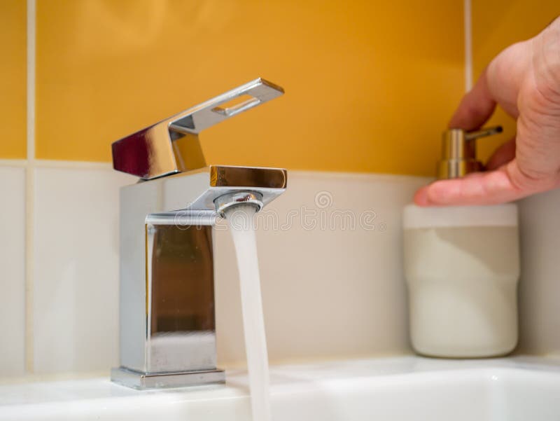 Using a Soap Dispenser for a Basin with a Square Faucet Stock Image ...