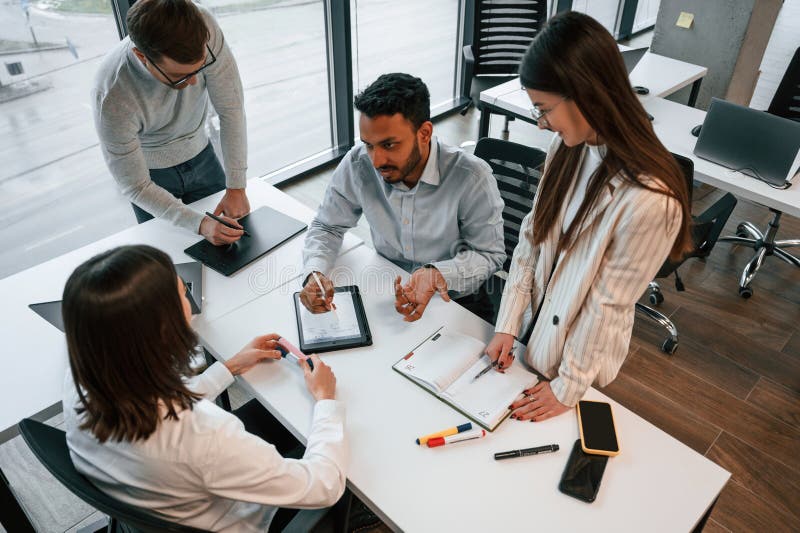 Using Tablet. Four People are Working in the Office Together Stock ...