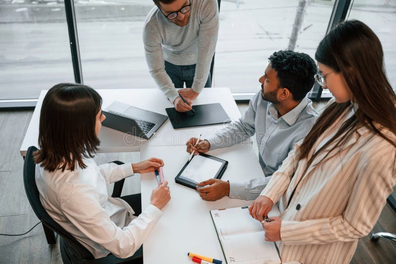 Using Tablet. Four People are Working in the Office Together Stock ...