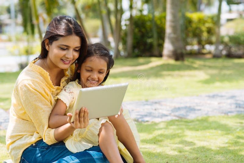 Using tablet in the park stock photo. Image of parent - 52271530