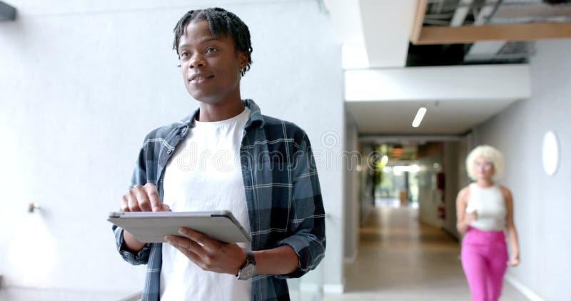 Using Tablet, Person Walking in Modern Office Hallway, Focusing on Work ...