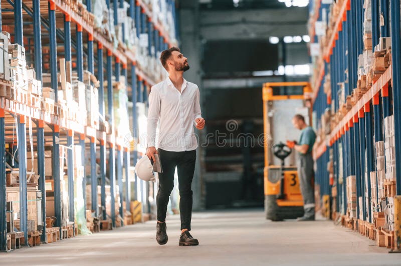 Using Tablet To Check the Products. Storage Worker is in the Warehouse ...