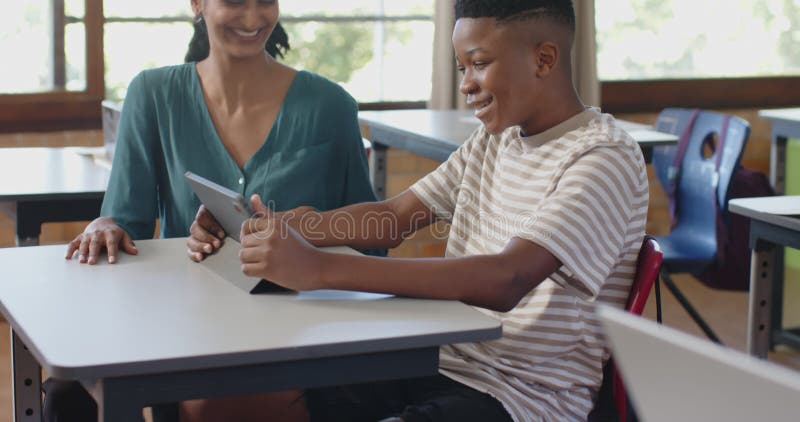 Using Tablet Together in School, Teacher and Student Smiling and ...