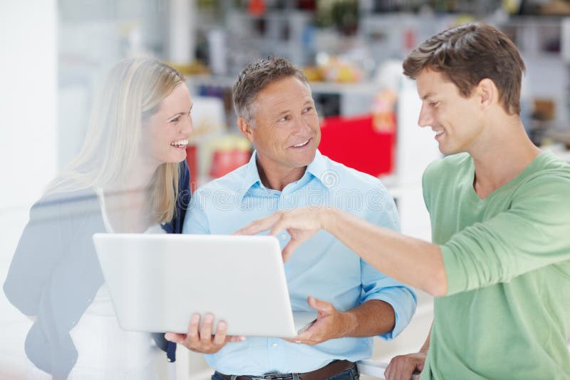 Using Technology To Their Advantage. Three Work Colleagues Working on ...