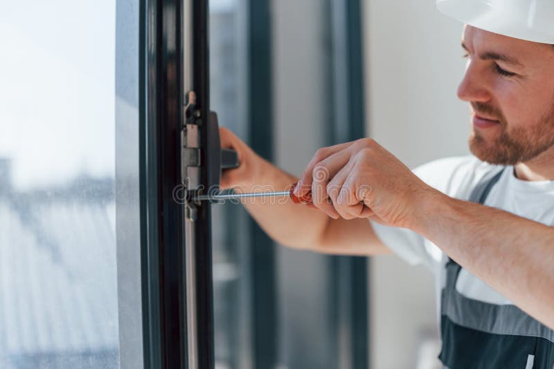 Using Tool on the Windows. Repairman is Working Indoors in the Modern ...