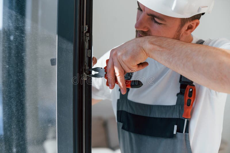 Using Tool on the Windows. Repairman is Working Indoors in the Modern ...