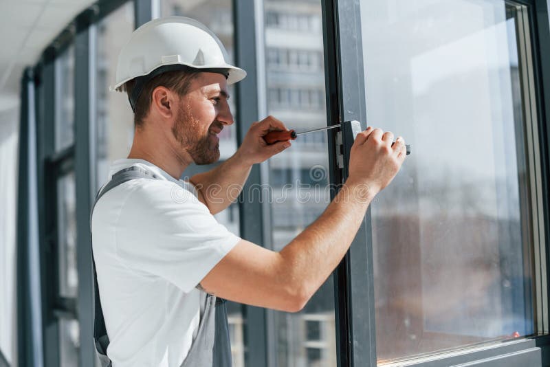 Using Tool on the Windows. Repairman is Working Indoors in the Modern ...